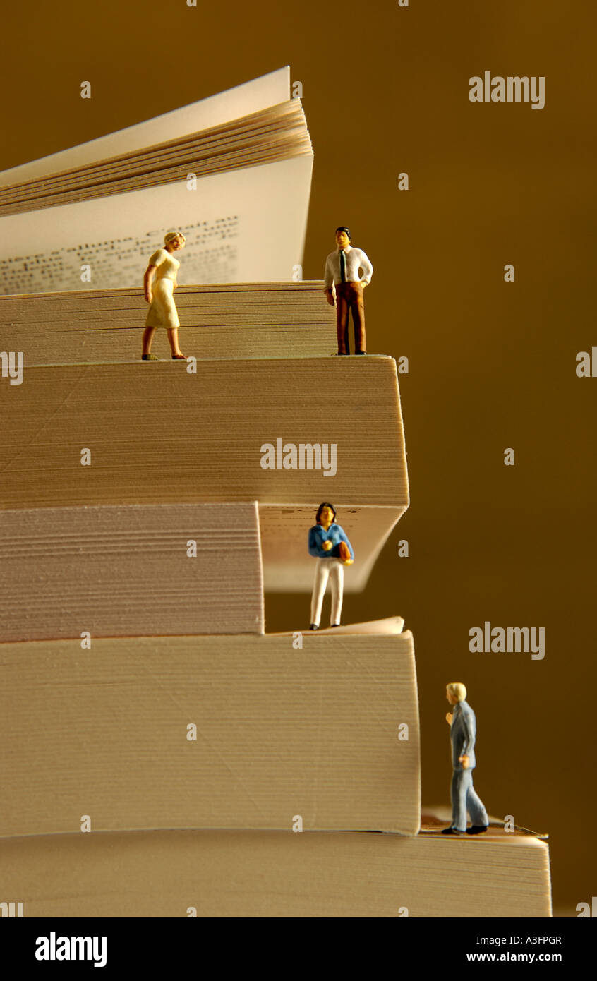 Figurines shaking hands on pile of books Stock Photo - Alamy