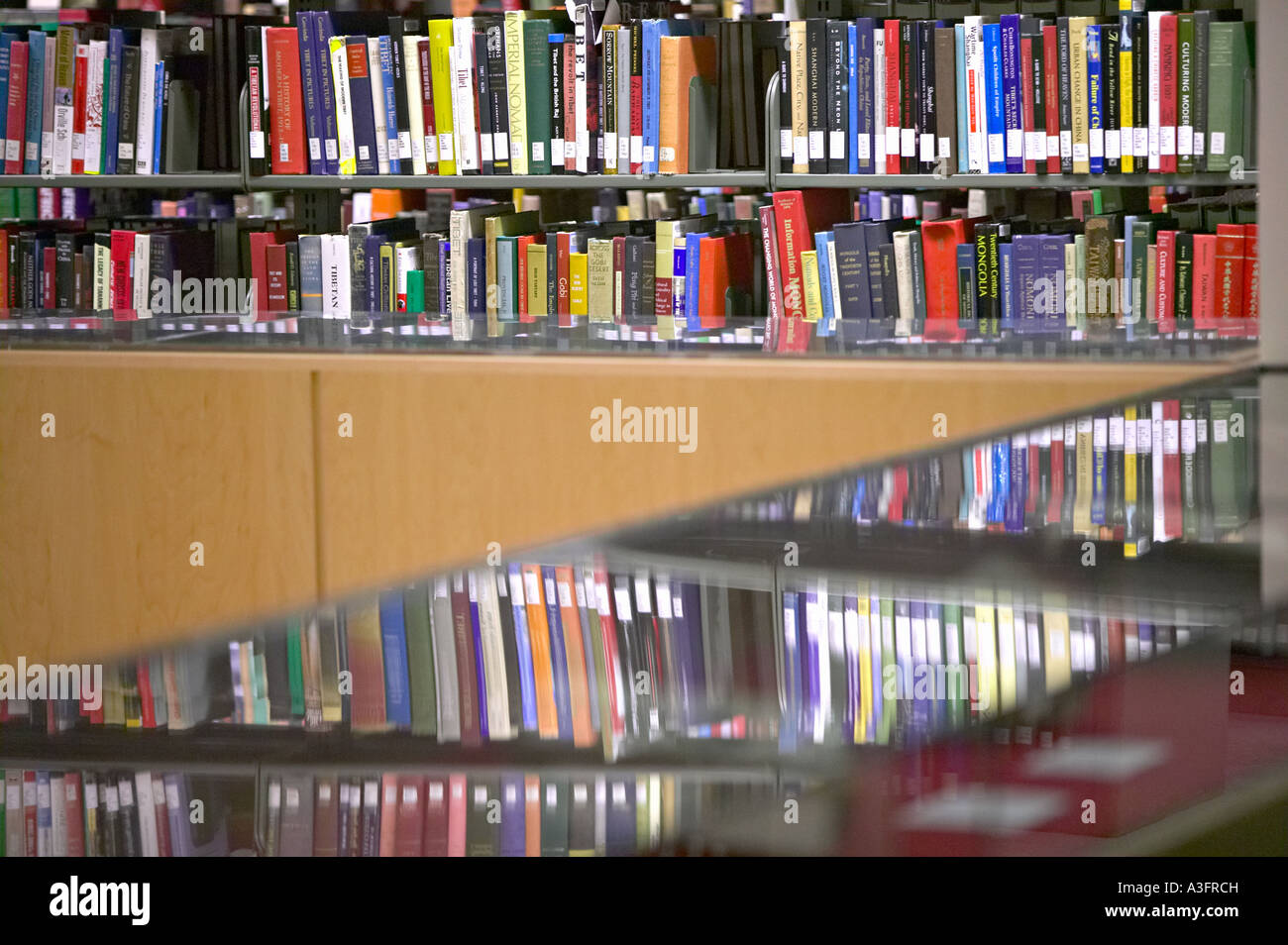 Library Books on shelves and reflecting in a glass display case ...