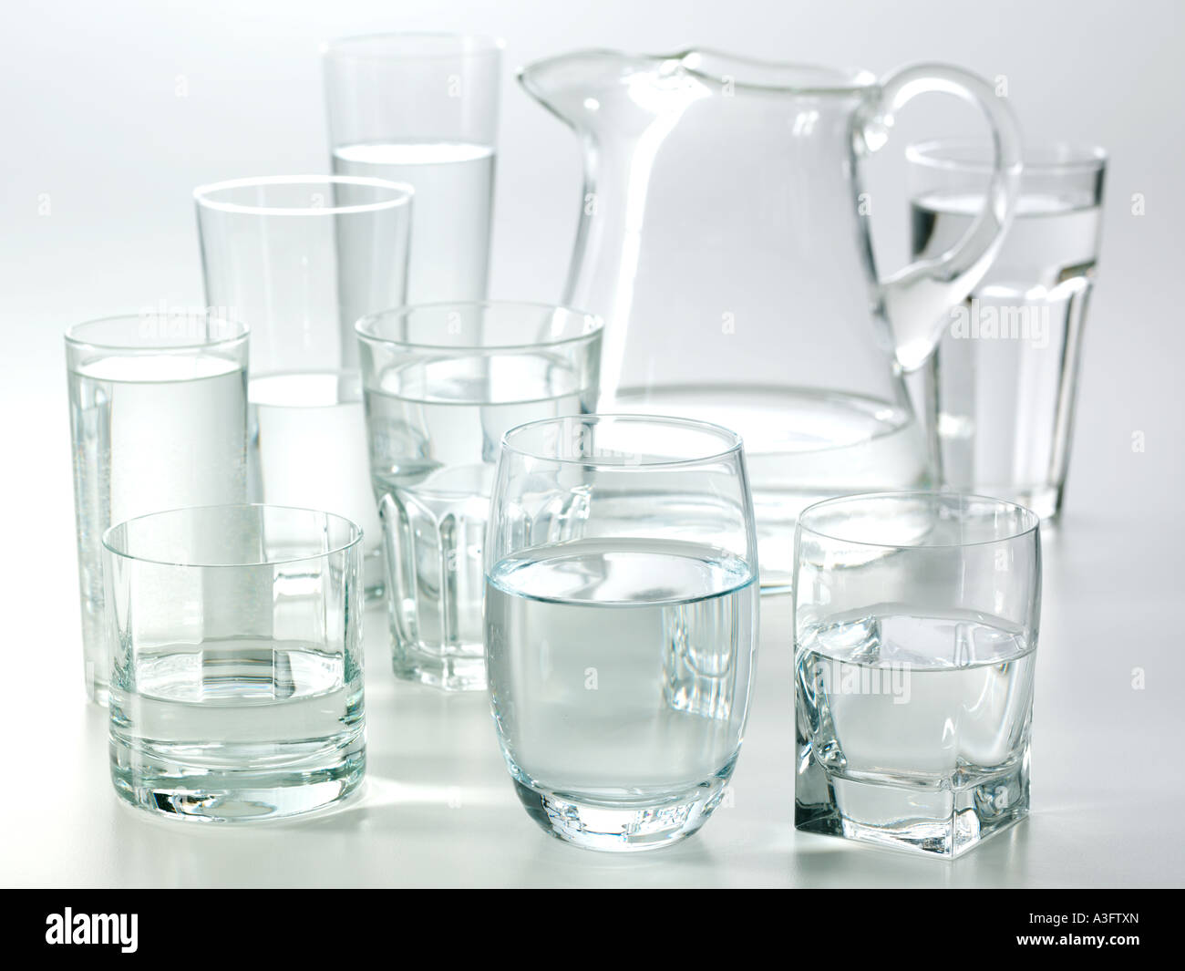 Glasses and a jug of water on a white background Stock Photo - Alamy