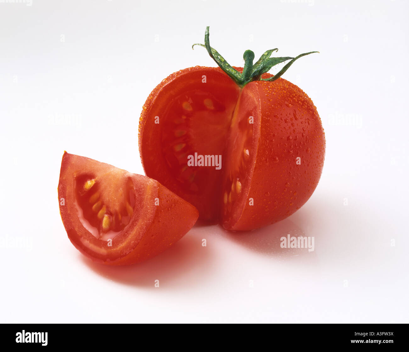 Cut tomato on a white background editorial food Stock Photo - Alamy