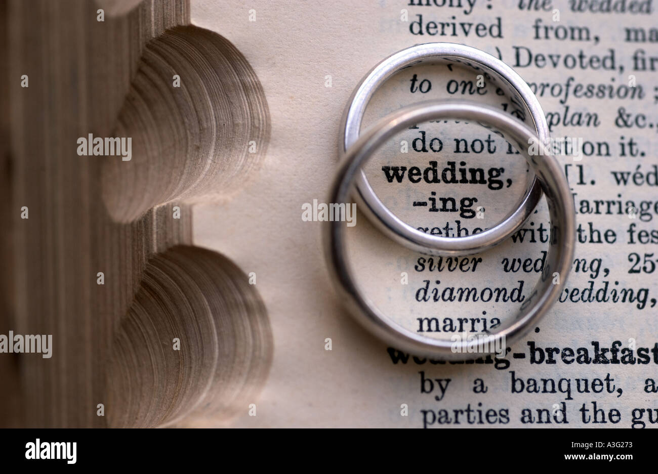 Wedding rings on a dictionary showing the word wedding Stock Photo - Alamy