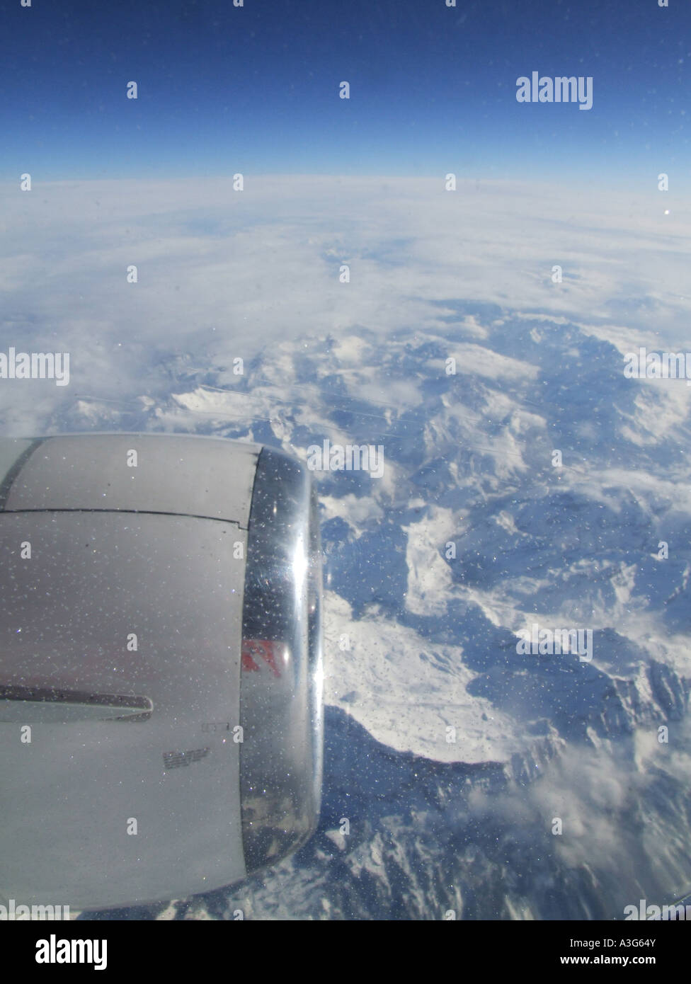 snow covered mountains seen from plane window Stock Photo - Alamy