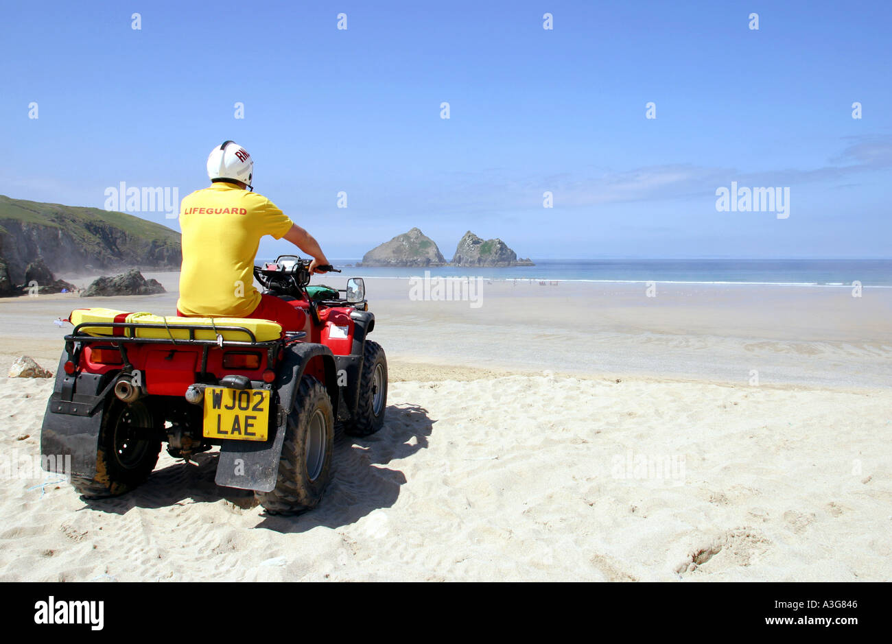 RNLI Beach Lifeguard on quad bike patrol at Holywell Bay Cornwall Stock ...