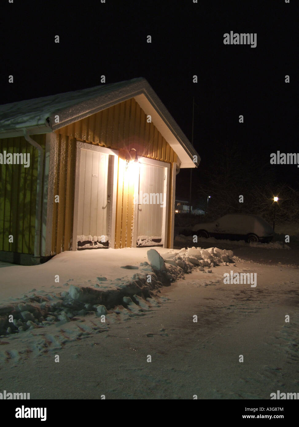 single garage by snow covered street at night in sweden Stock Photo - Alamy