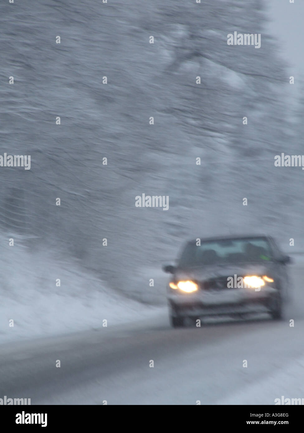 one car driving in heavy snow with headlights on Stock Photo - Alamy