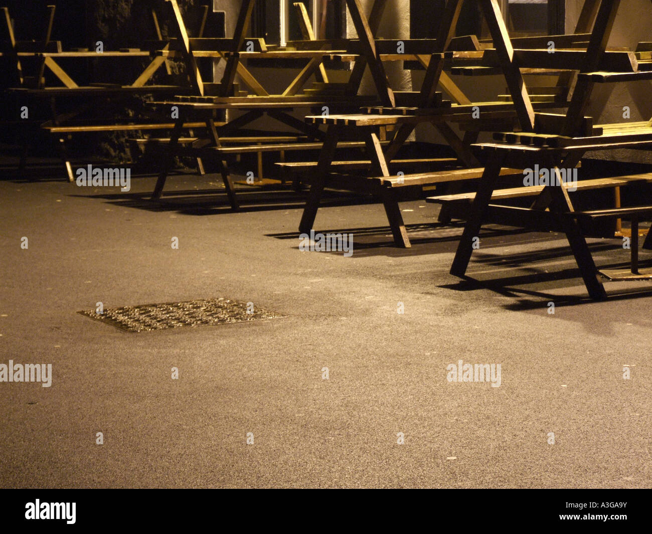 stacked wooden benches and tables outside pub at night Stock Photo - Alamy