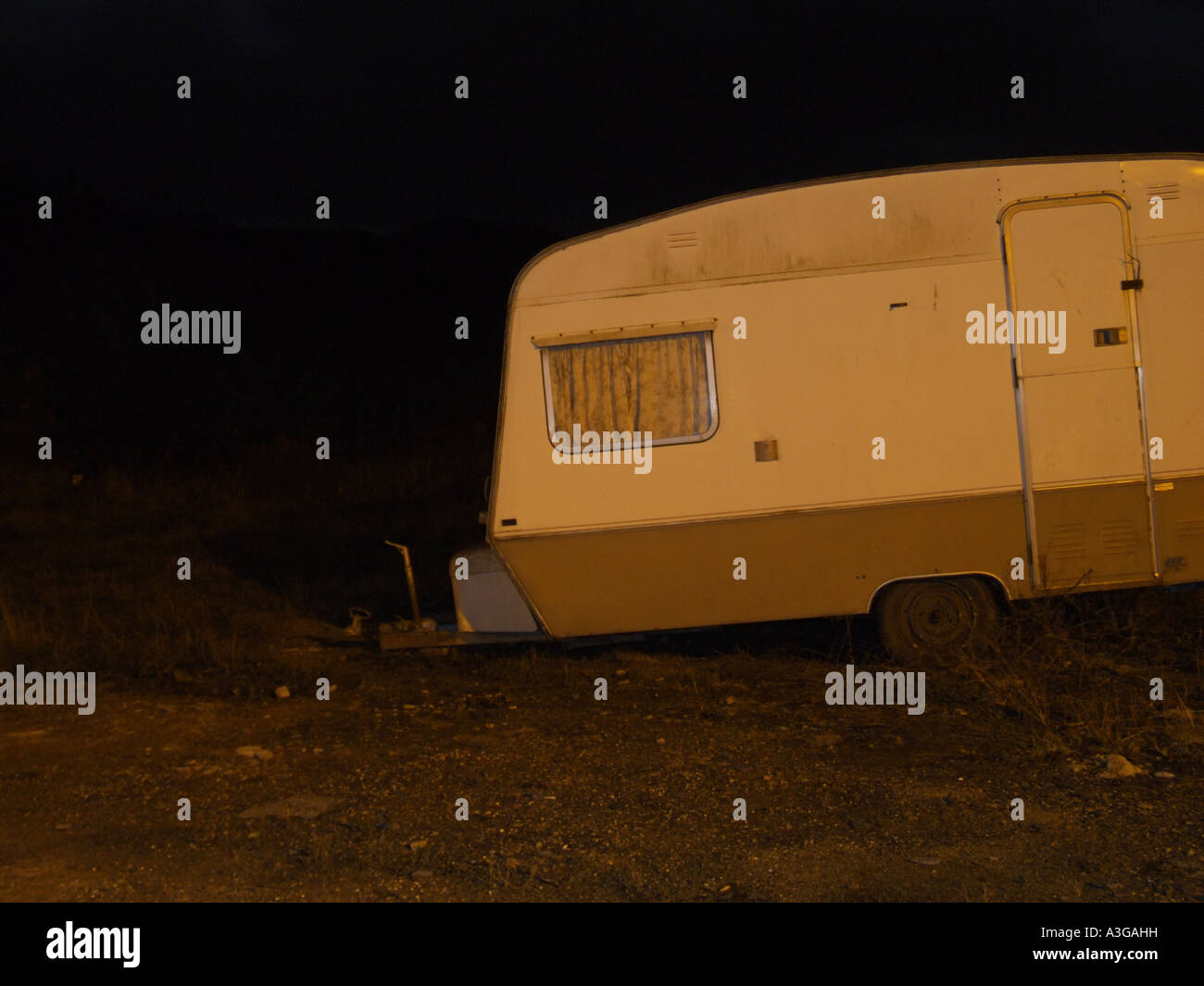 one caravan on derelict ground at night Stock Photo - Alamy