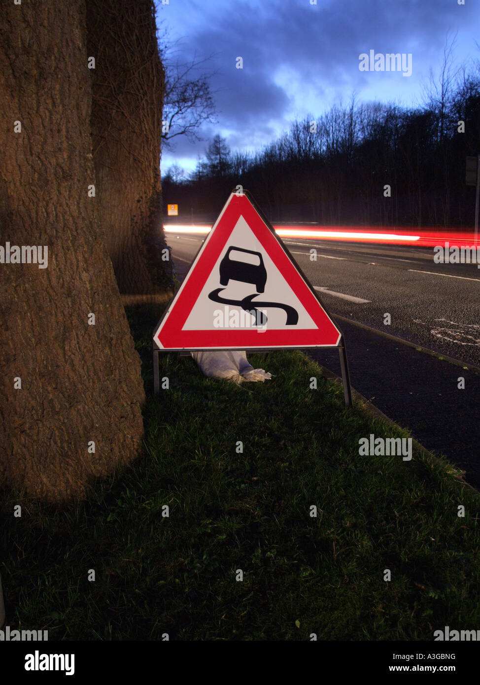slippery road sign with fast traffic at night Stock Photo - Alamy