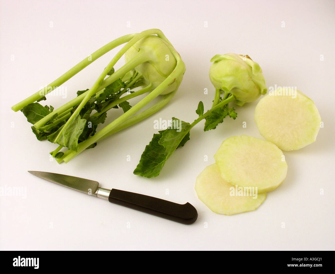 one kohlrabi cut into slices and white background Stock Photo - Alamy