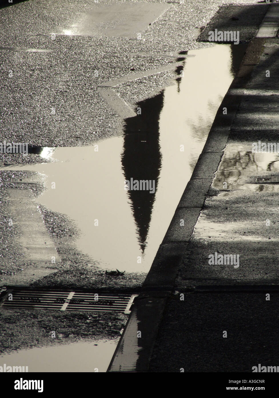 building reflected in a puddle of water on wet street Stock Photo - Alamy