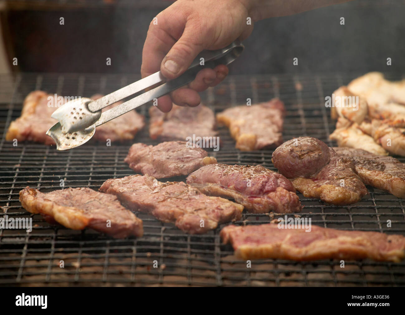 CHICKEN AND BEEF STEAKS COOKING ON A BARBECUE Stock Photo - Alamy