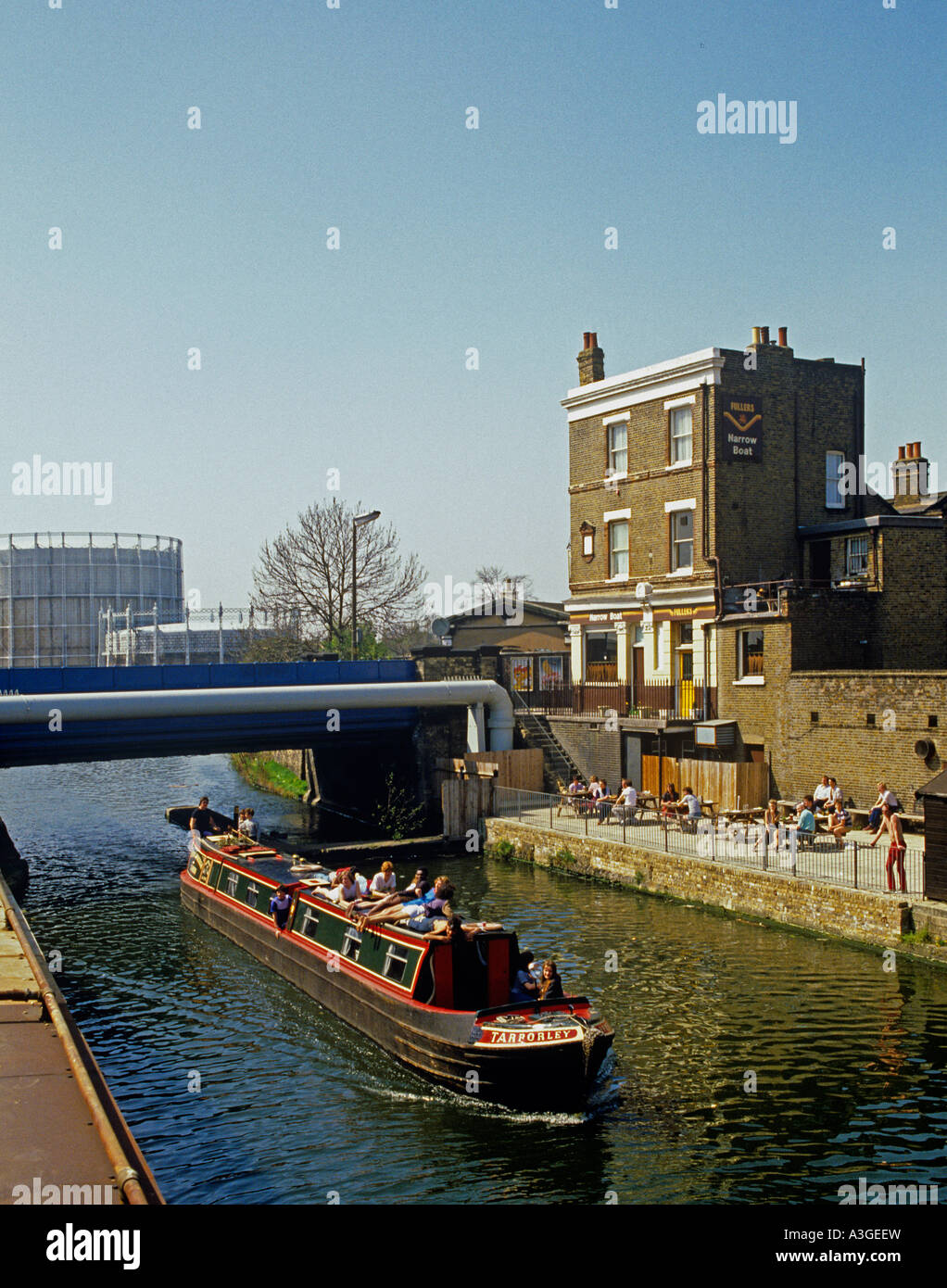 Narrowboat tour boat passing Fullers pub by the side of The Grand Union ...