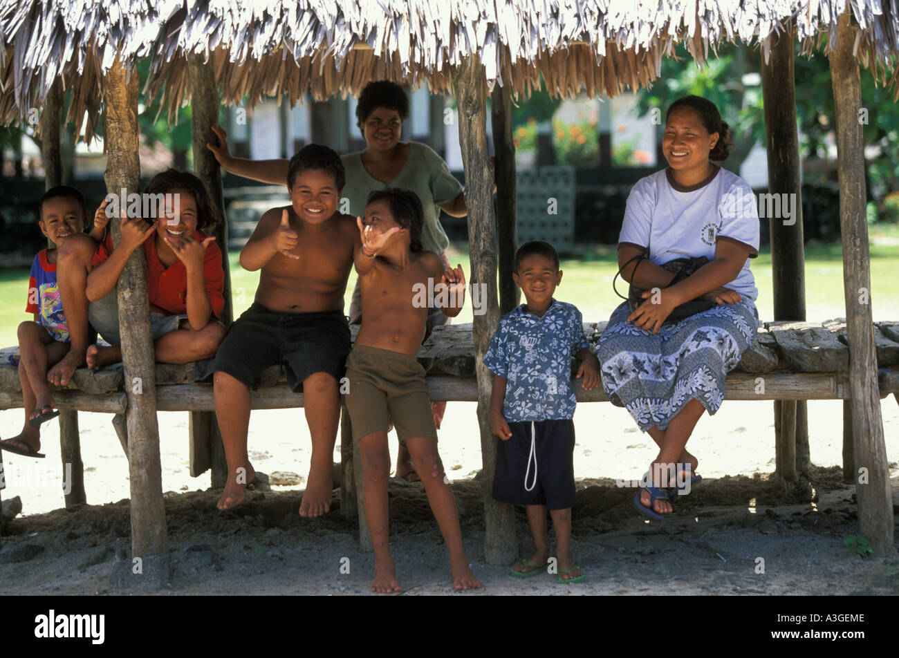 Happy Samoans inside a small open hut or fale beside the road in Faga ...