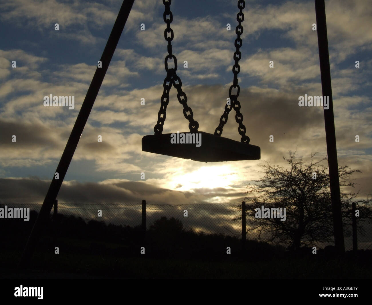 one swing in play ground against dramatic moody sky Stock Photo - Alamy