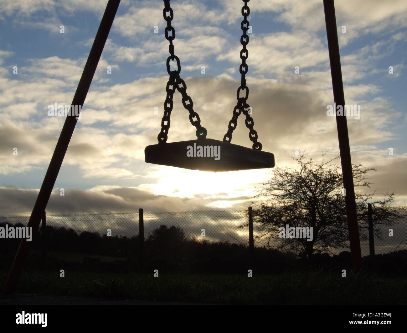 one swing in play ground against dramatic moody sky Stock Photo - Alamy