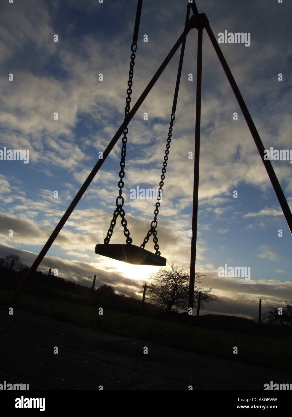 one swing in play ground against dramatic moody sky Stock Photo - Alamy