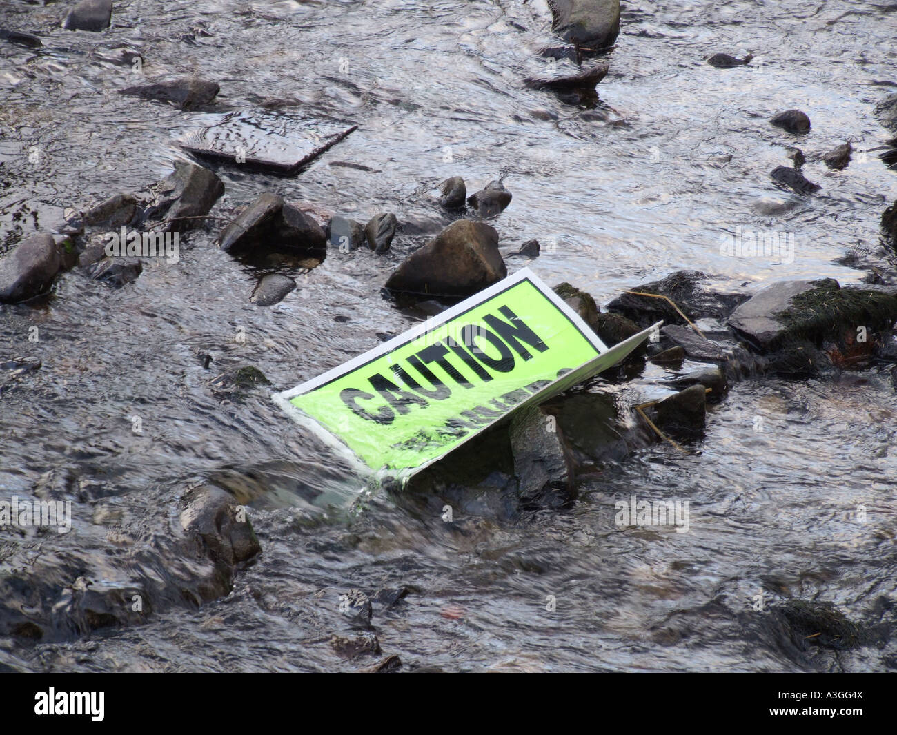 bright green caution sign discarded in river Stock Photo - Alamy