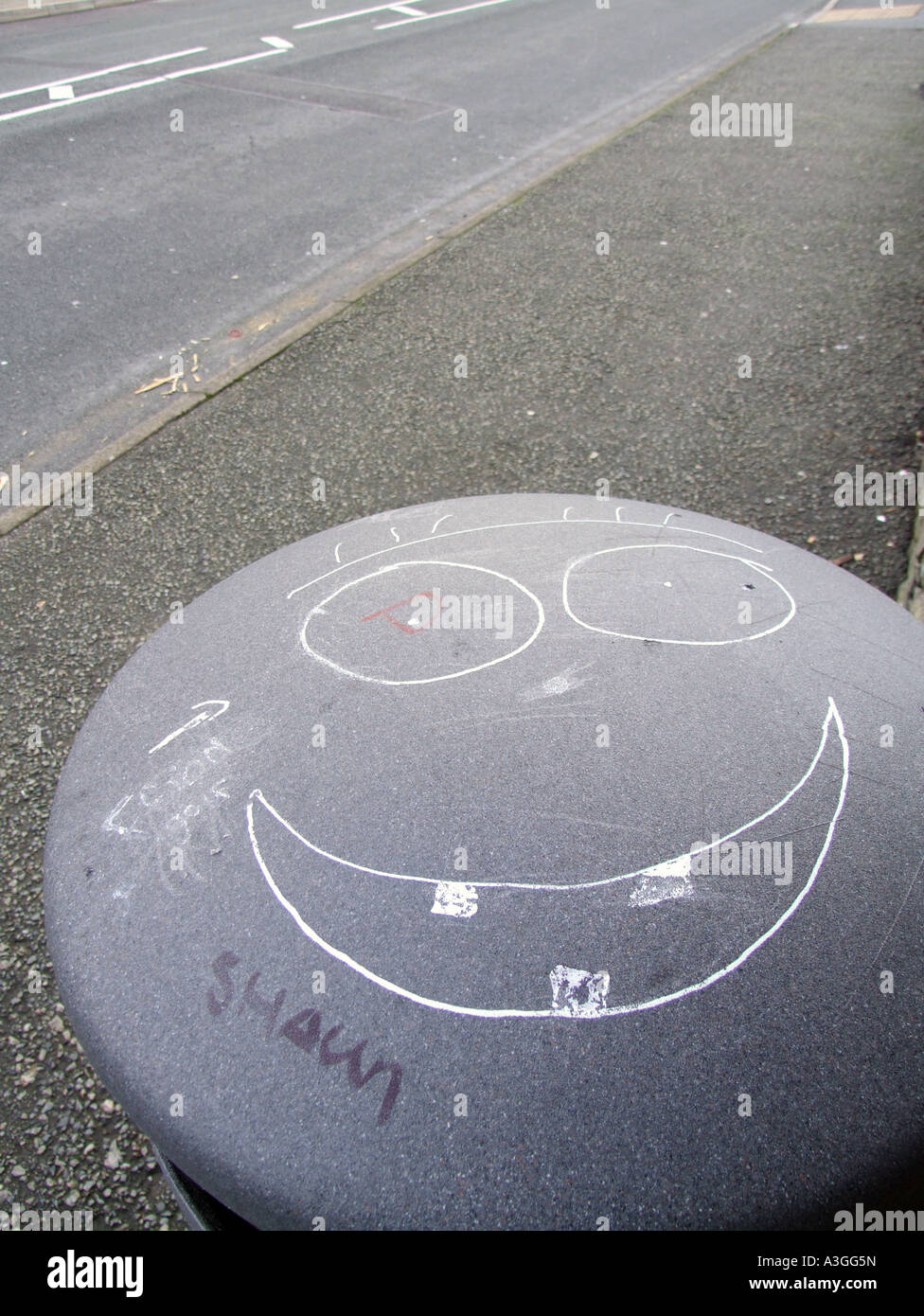 one smiley face graffiti on litter bin Stock Photo - Alamy