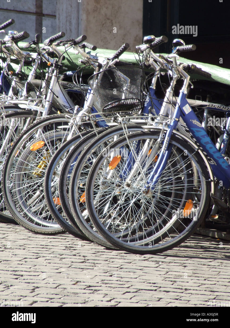 a row of parked bikes outdoors in sun Stock Photo - Alamy