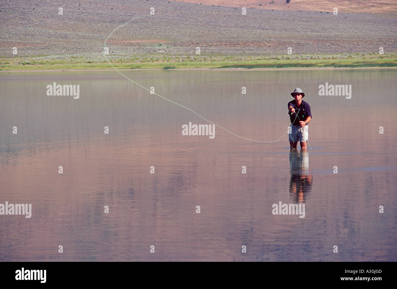 Stock Photo flyfisherman reflection wading casting Mann Lake Northern ...