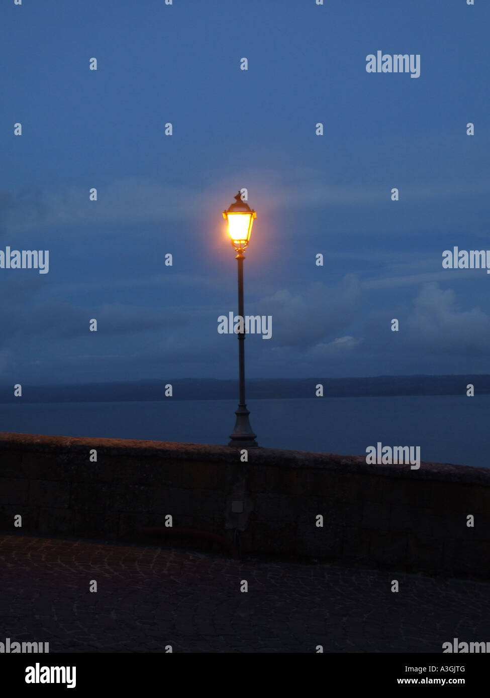 one lamp post by sea at night Stock Photo - Alamy