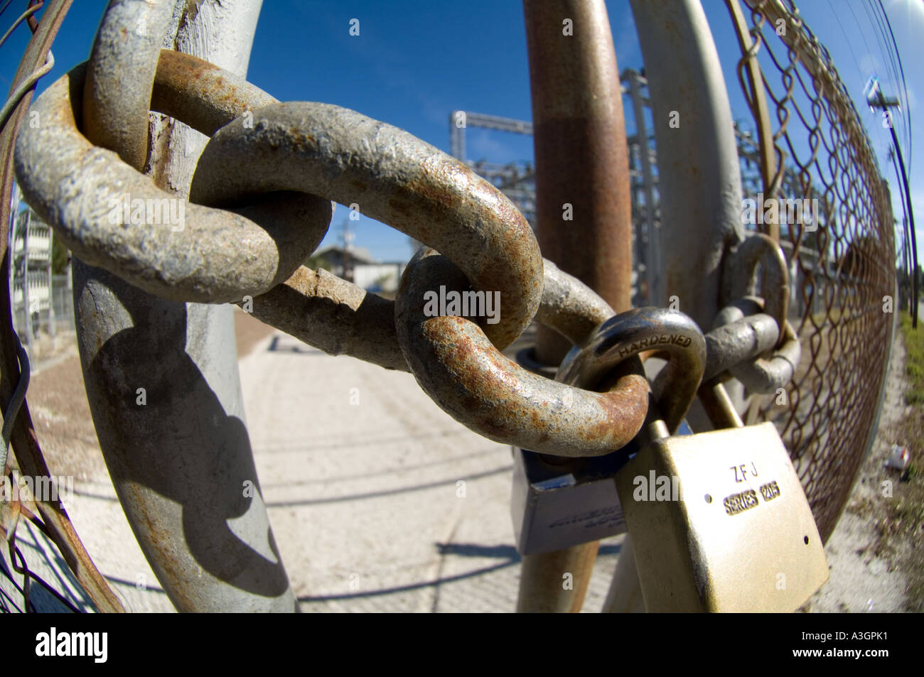 closeup fish eye view of padlock and chain link fence at power ...