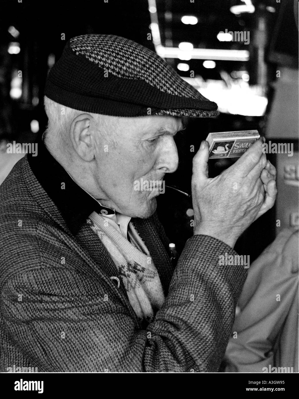 Old man lighting cigarette with Swan matches in amusement arcade Stock ...