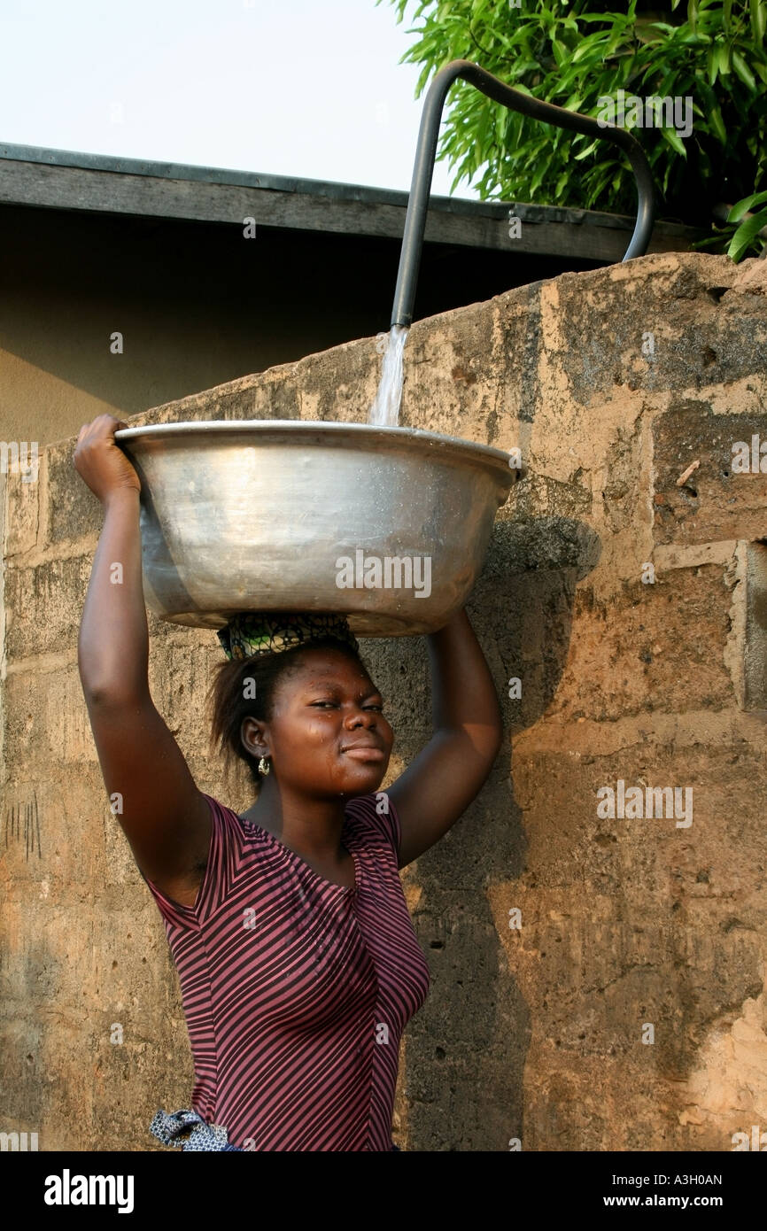 Lady collecting water from a communal pipe , Abomey , Benin Stock Photo ...