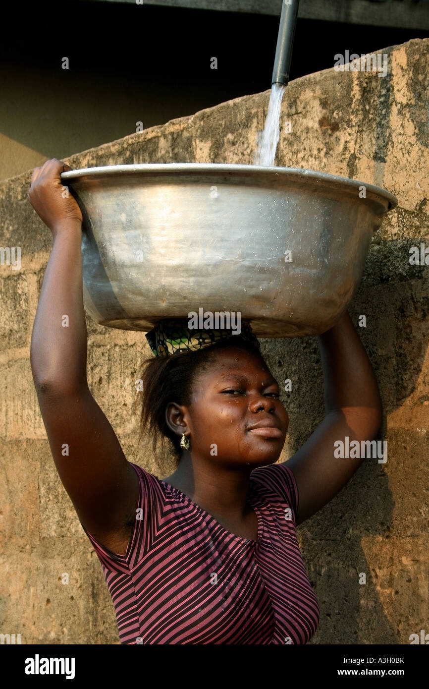 Lady collecting water from a communal pipe , Abomey , Benin Stock Photo ...