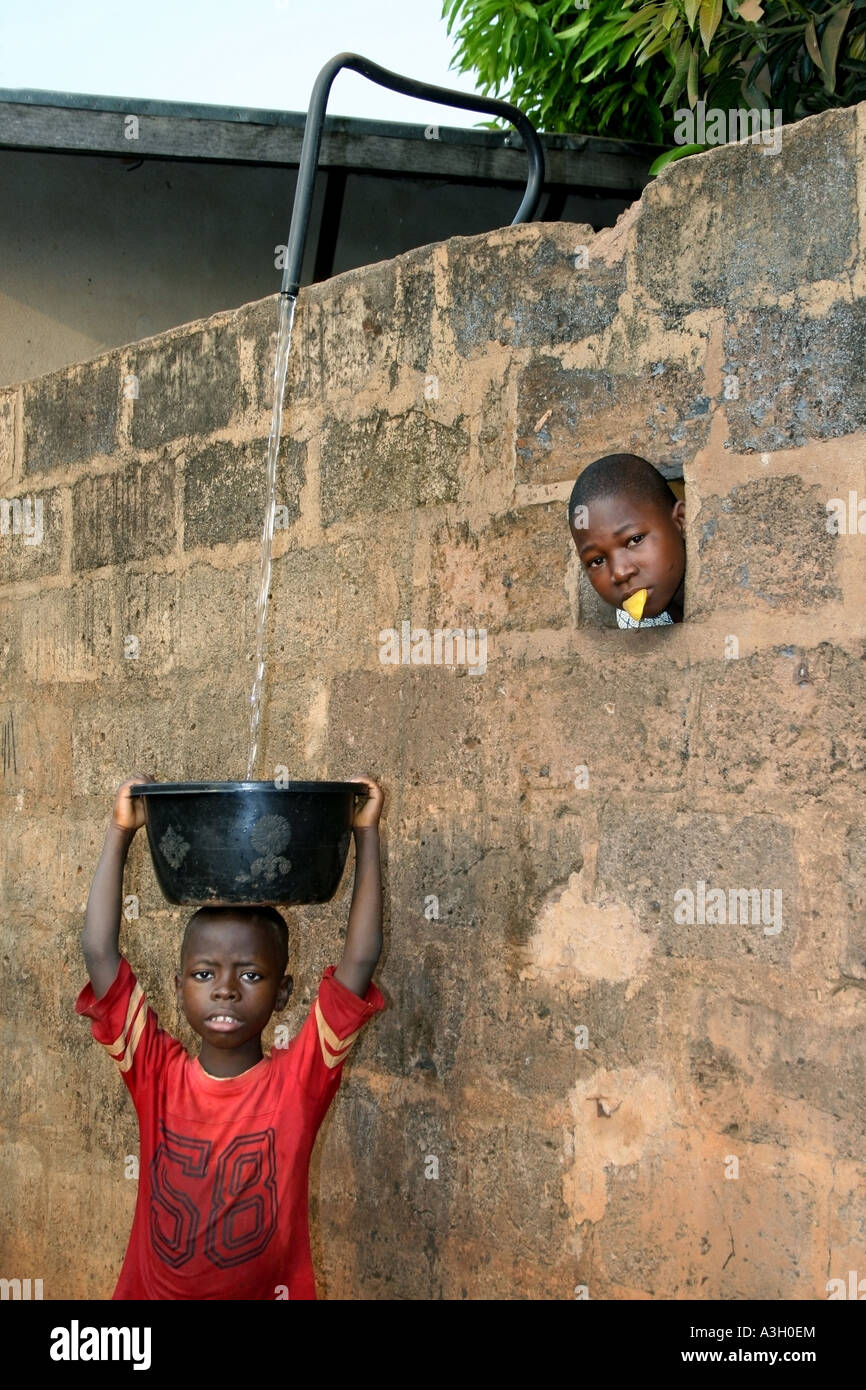 Boy collecting water from a communal pipe , Abomey , Benin Stock Photo ...