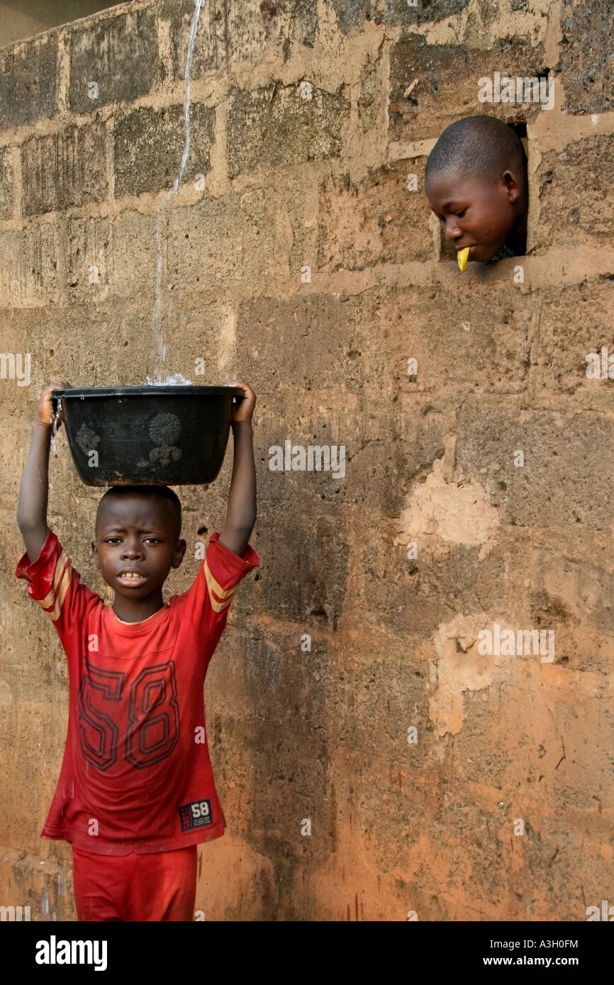 Boy collecting water from a communal pipe , Abomey , Benin Stock Photo ...