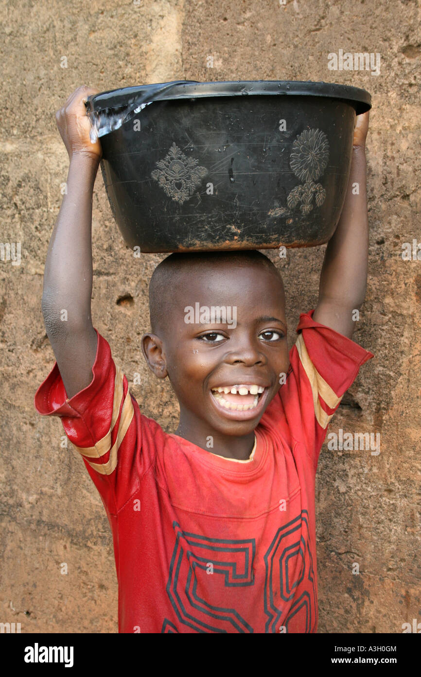 Boy collecting water from a communal pipe , Abomey , Benin Stock Photo ...