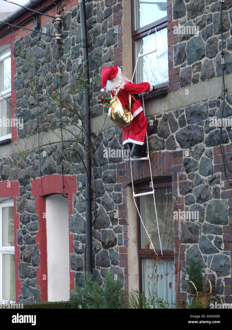 father christmas climbing house roof to deliver presents Stock Photo ...