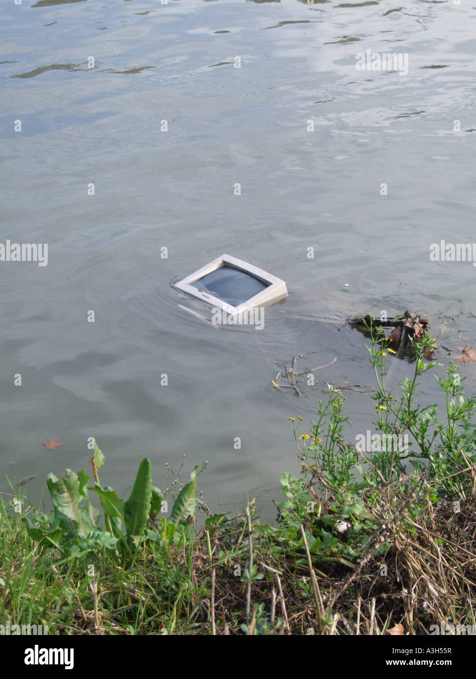 old pc computer monitor dumped in river Stock Photo - Alamy