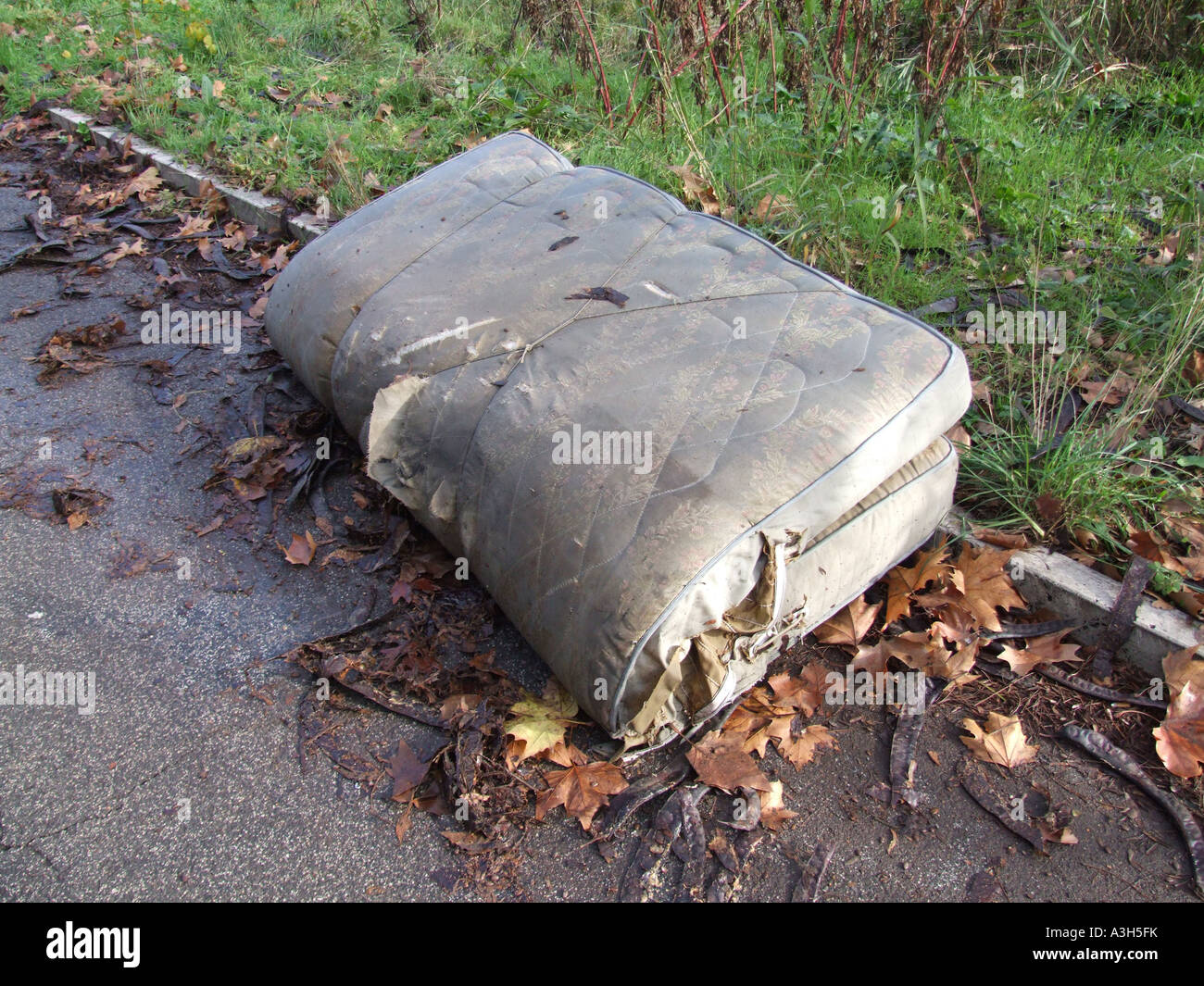 old mattress dumped on country lane Stock Photo - Alamy