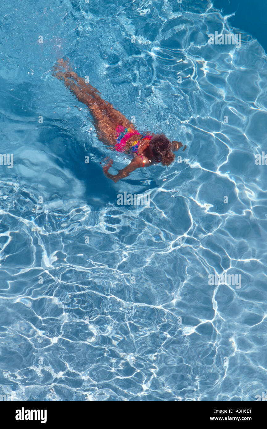 overhead shot of woman swimming in resort pool Kauai Hawaii USA US U S ...