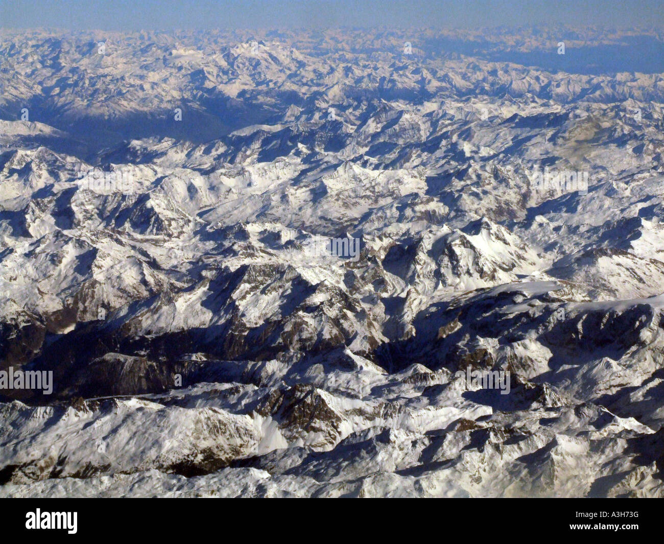 snow covered mountain range seen from plane window Stock Photo - Alamy