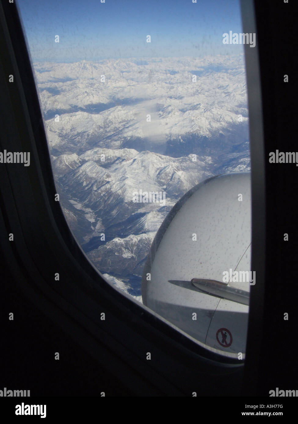 snow covered mountain range seen from plane window Stock Photo - Alamy