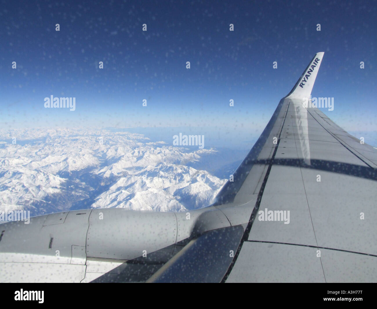 snow covered mountains seen from plane window Stock Photo - Alamy