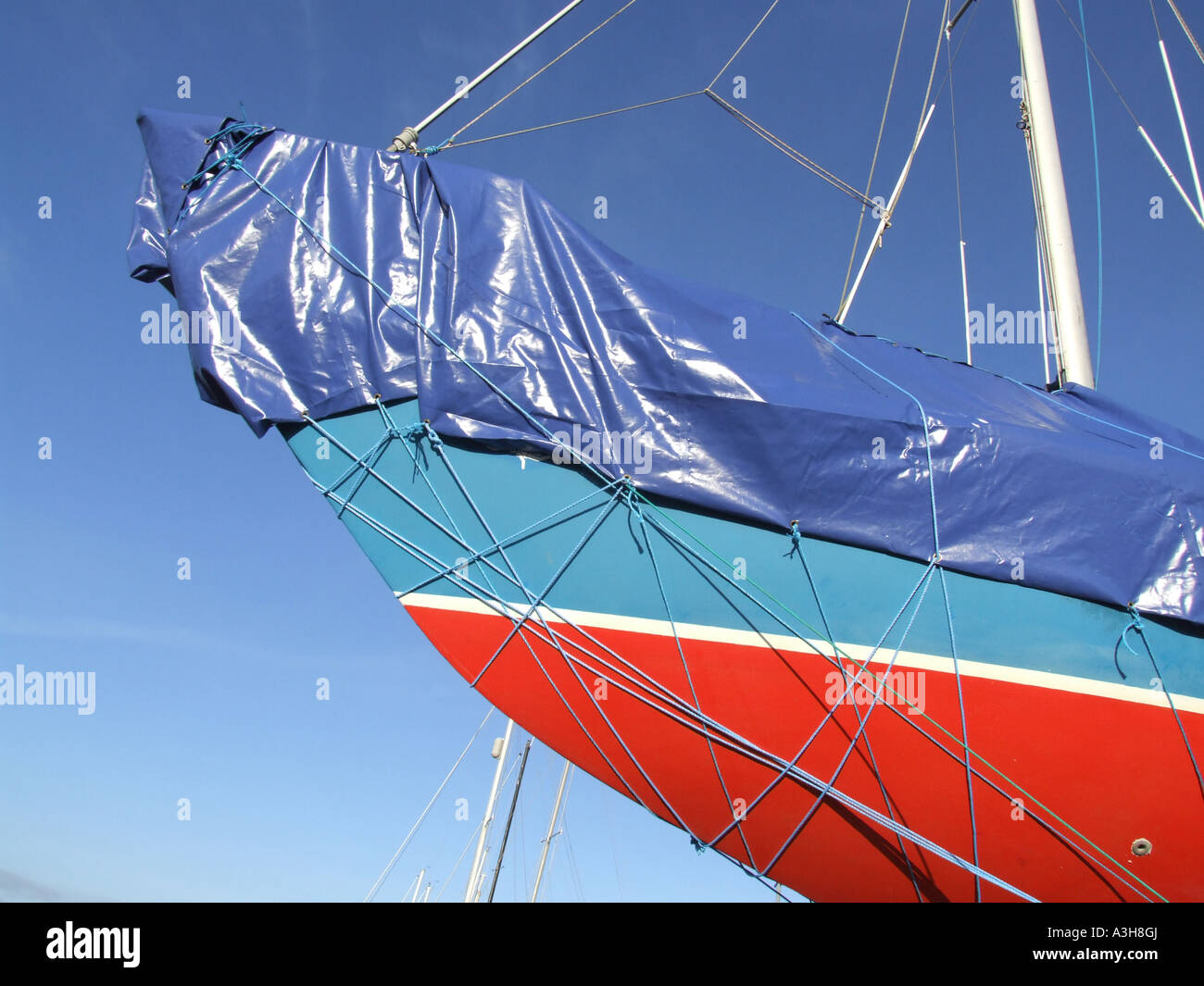 luxury yacht with blue cover and lots of tangled rope Stock Photo - Alamy
