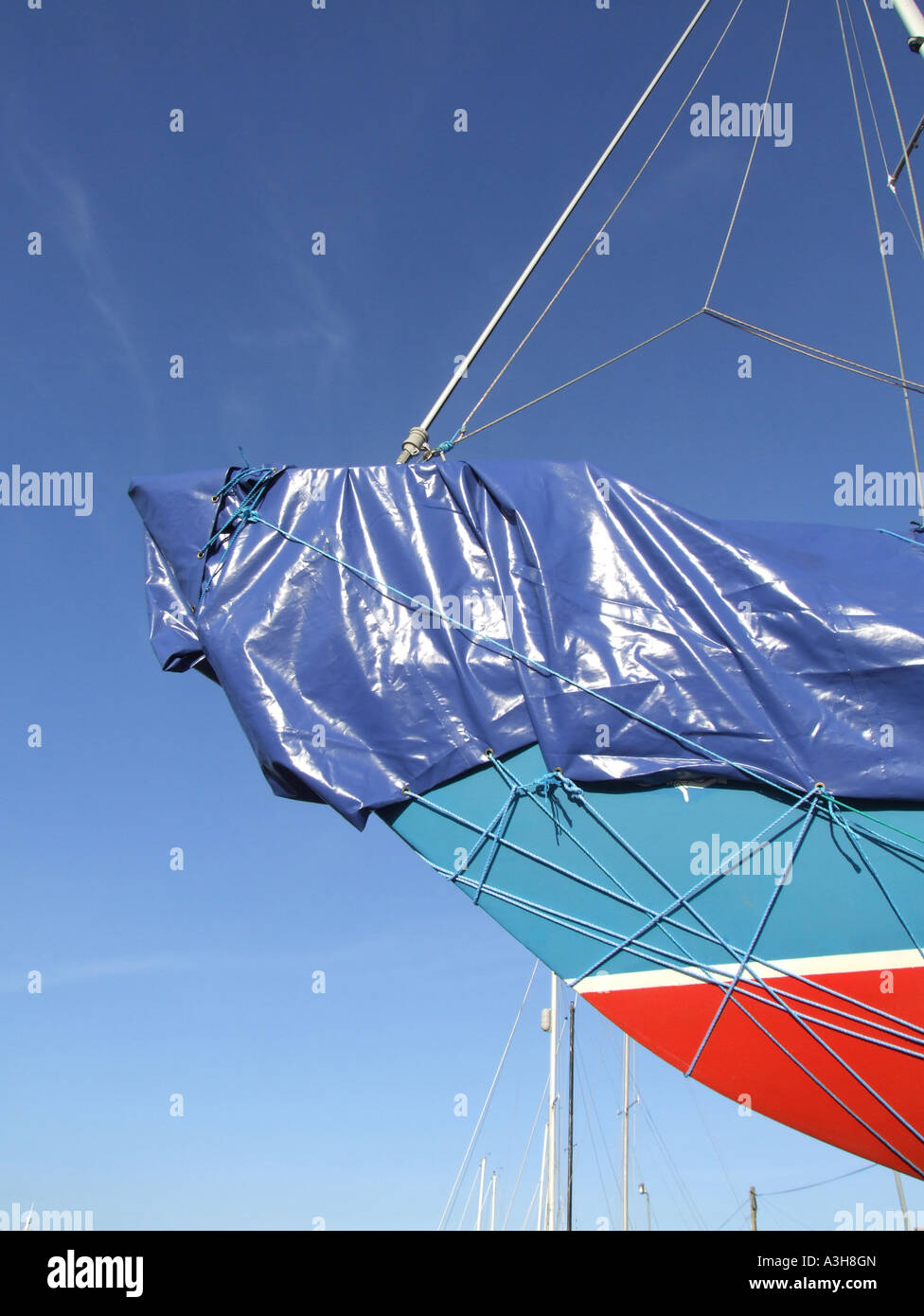 luxury yacht with blue cover and lots of tangled rope Stock Photo - Alamy