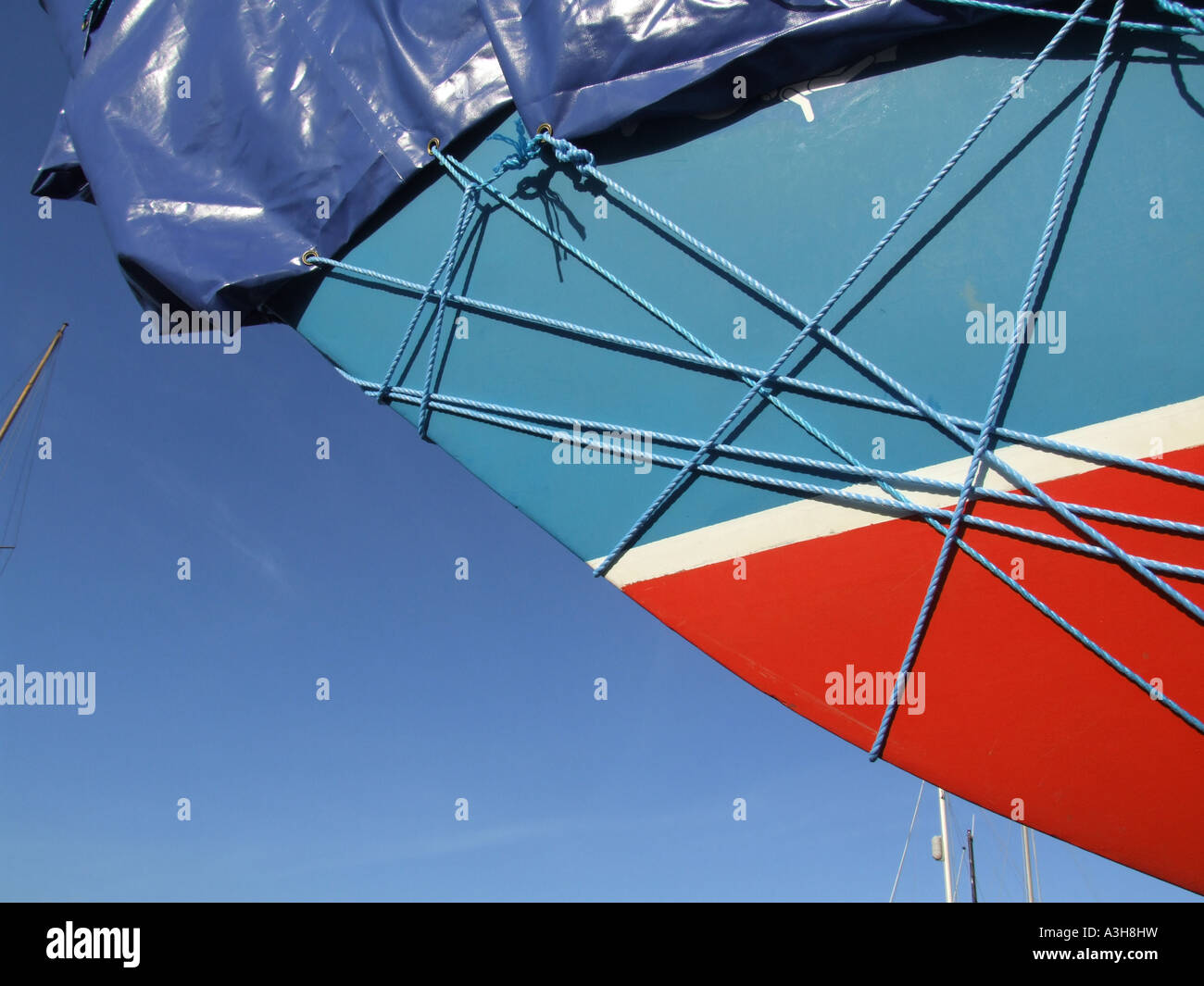 luxury yacht with blue cover and lots of tangled rope Stock Photo - Alamy