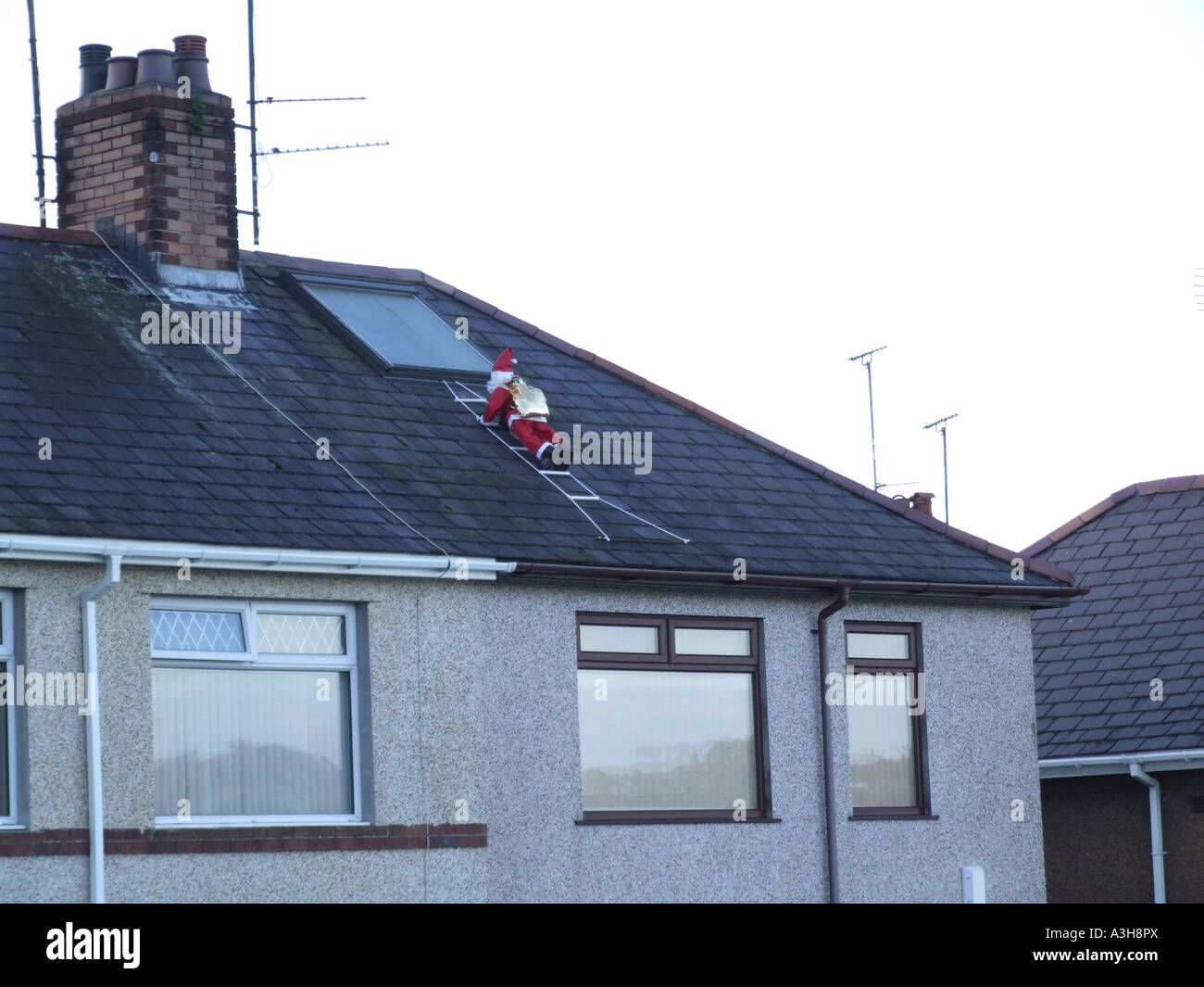 father christmas climbing house roof to deliver presents Stock Photo ...