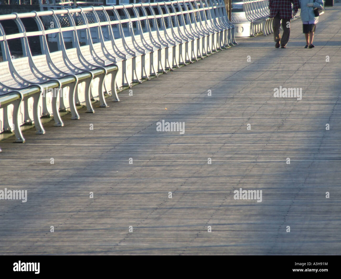 elderly couple walking along promenade pier on sea side resort Stock ...