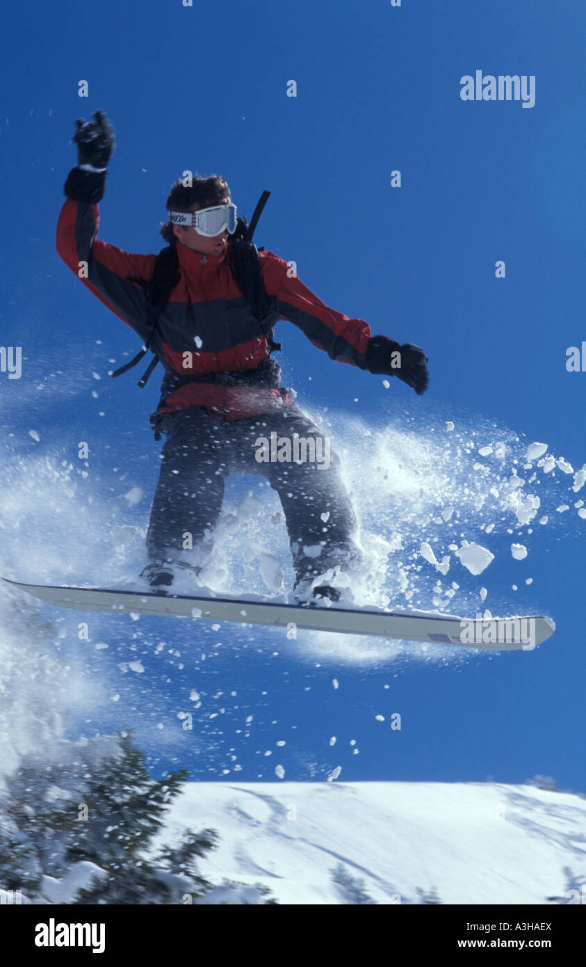 Snowboarder flying through the air above the snow Stock Photo - Alamy