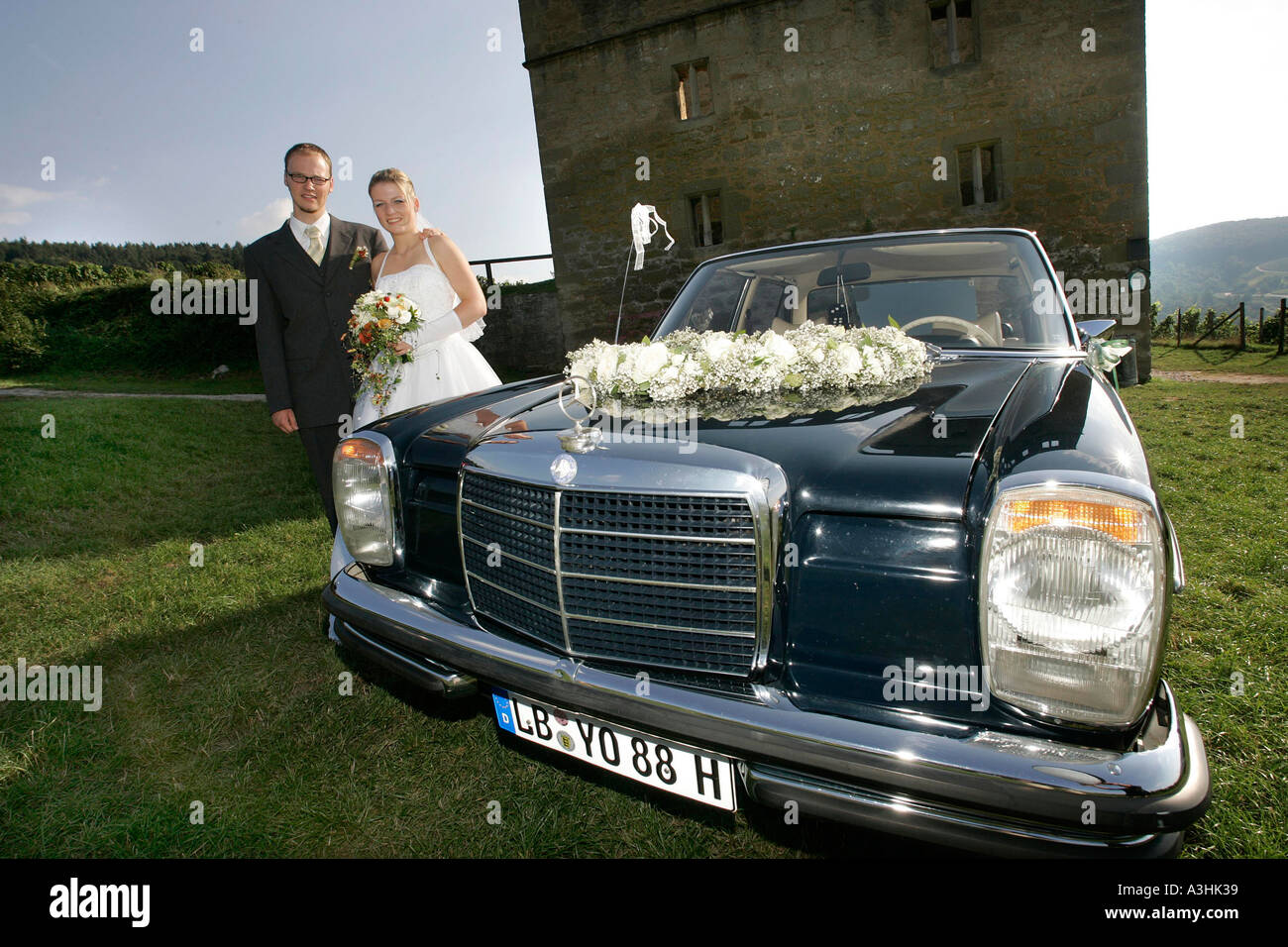 wedding couple standing beside a black oldtimer mercedes Stock Photo ...