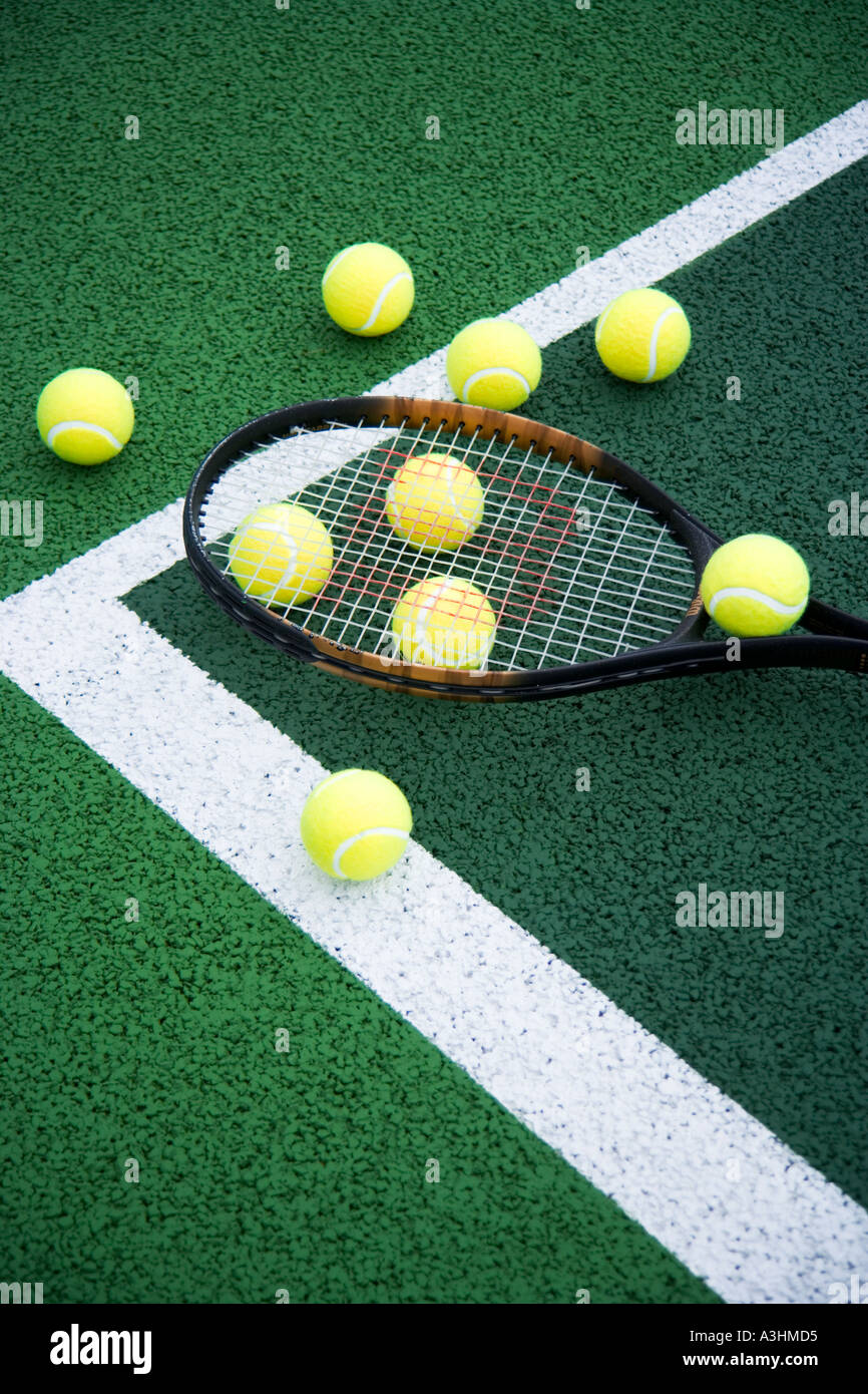 Tennis balls and racket lying on tennis court Stock Photo - Alamy