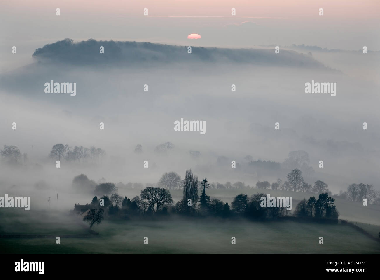 Cam Long Down shrouded in mist from Coaley Peak on the Cotswold Way ...