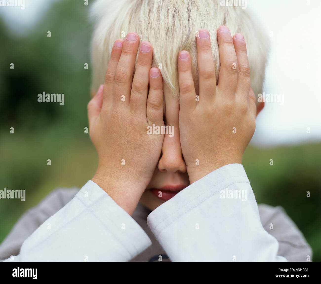 Young boy with hands over his eyes Stock Photo - Alamy