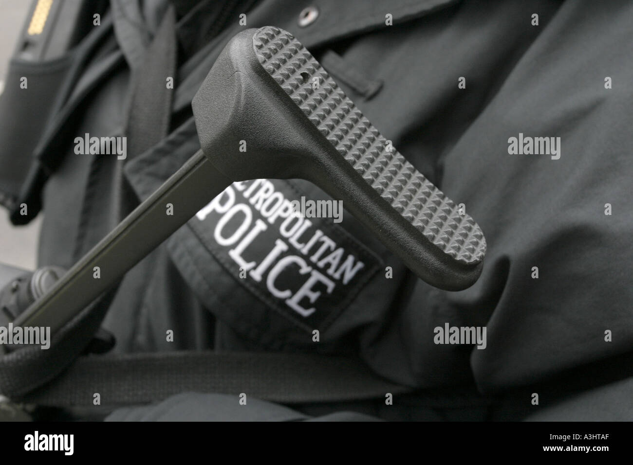 Matte black Metropolitan Police uniform with close up of semi automatic ...